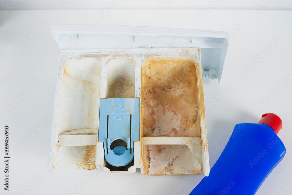 Dirty white dispenser container for washing powder. Poor running water ...