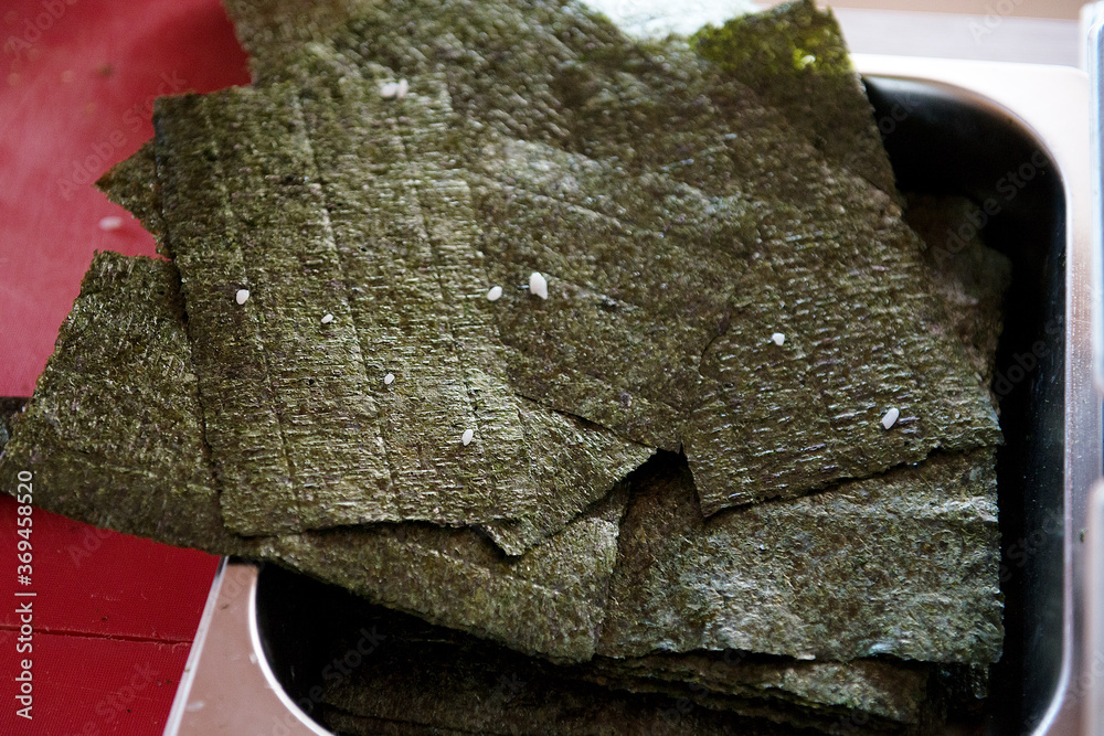 Sheets of nuri seaweed in a metal container on the table, close-up ...
