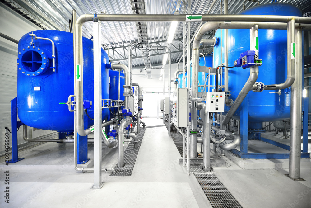 Large blue tanks in a industrial city water treatment boiler room. Wide ...