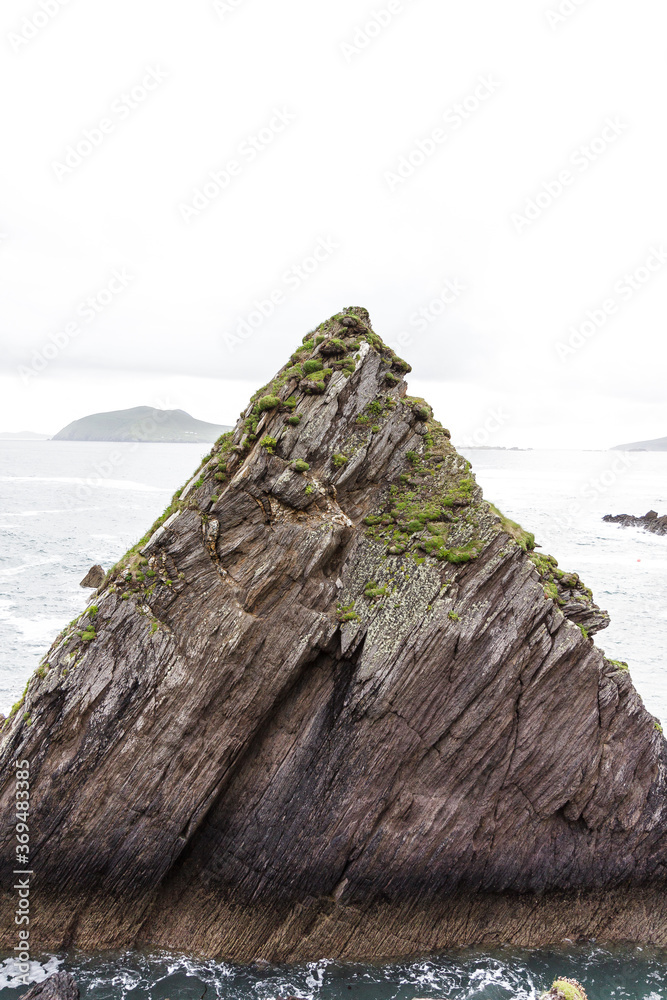 Beautiful single rock formation on the seashore, triangle shape ...