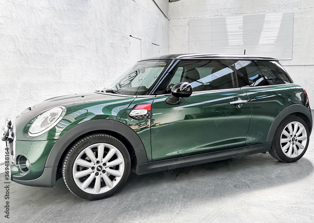 MINI car in racing green color side view in dealership interior of mini ...