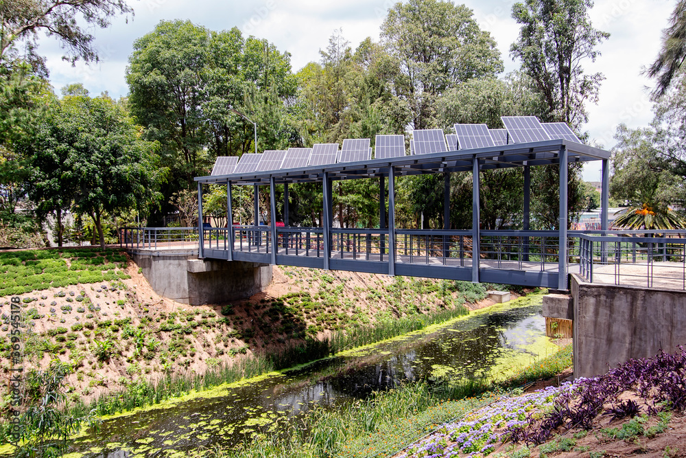 A modern bridge in a park with sollar cells. This allows to power ...