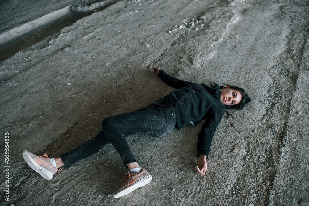 Foto de Corpse of female victim of crime lying down on the ground of ...