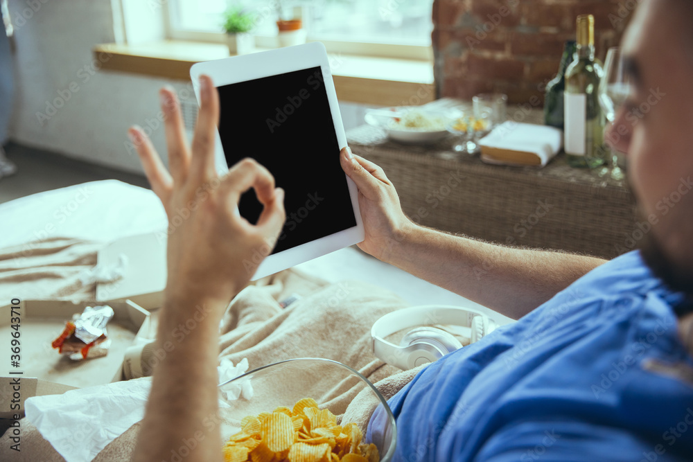 Eating crisps, nice gesture. Lazy man living in his bed surrounded with ...