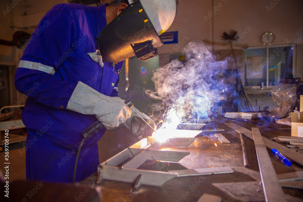 Welder is assembling the workpiece by process shielded metal arc ...