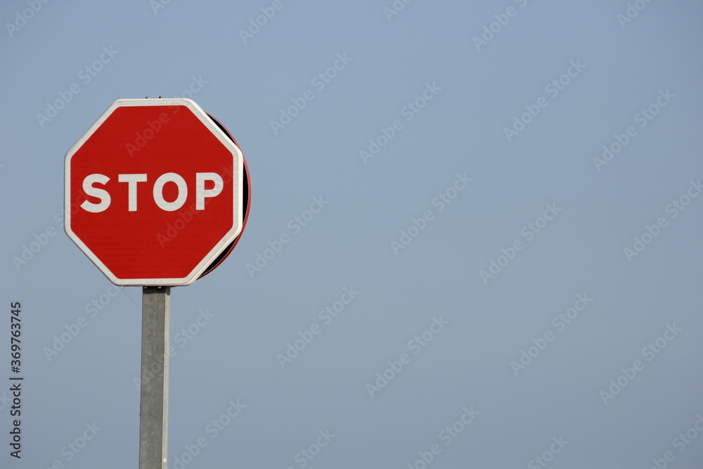 señal de stop con fondo azul Stock Photo | Adobe Stock