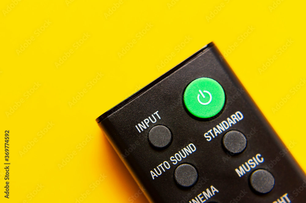 Black TV remote control on bright yellow background flat lay top view ...