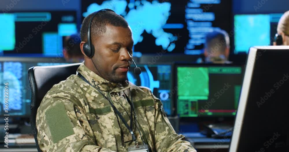 African American male army officer in headset talking and working on ...