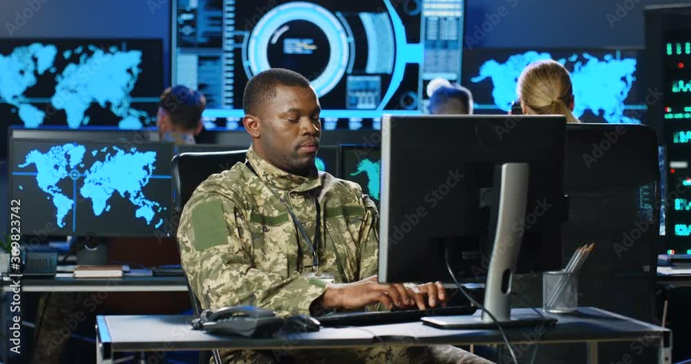 African American male army officer in uniform sitting at desk, working ...