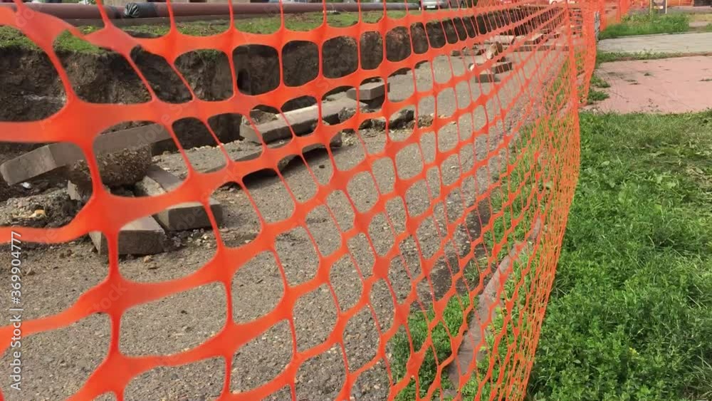 Red mesh fence danger. Open trench with pipes of the heating ...