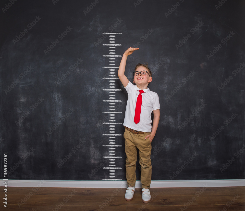 Little kid boy measuring himself. School boy measuring his growth in ...