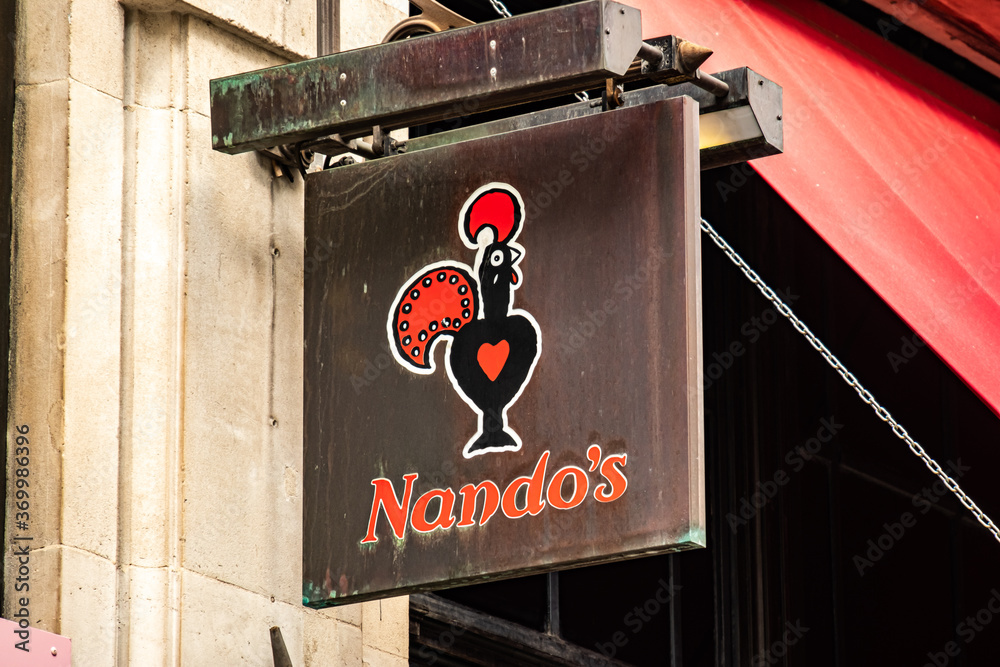 London- Nandos logo on exterior signage, a popular grilled chicken high ...