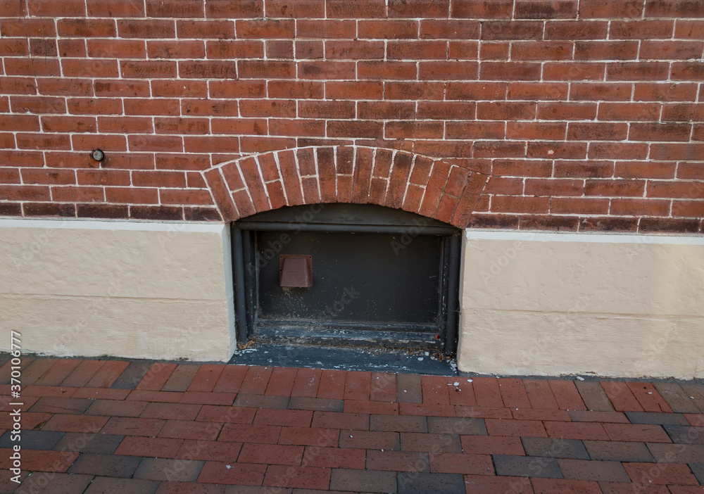 vented basement window surrounded by brick wall and pavement Stock ...