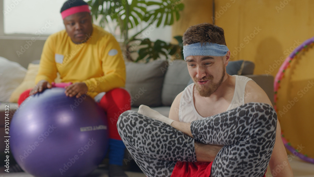 Extraordinary bearded sportsman grimacing and lifting his both legs ...