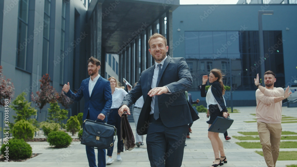 Excited multi-thnic office staff dancing on street after working day ...
