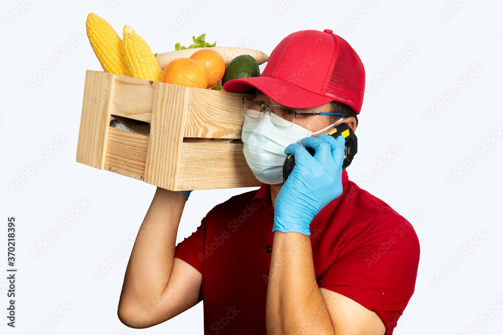 Delivery man carrying box of vegetable and phone call with customer ...