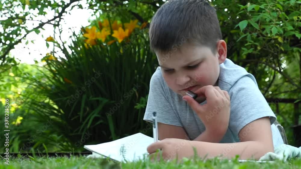 close up serious kid boy writing in notebook. Portrait of schoolboy ...