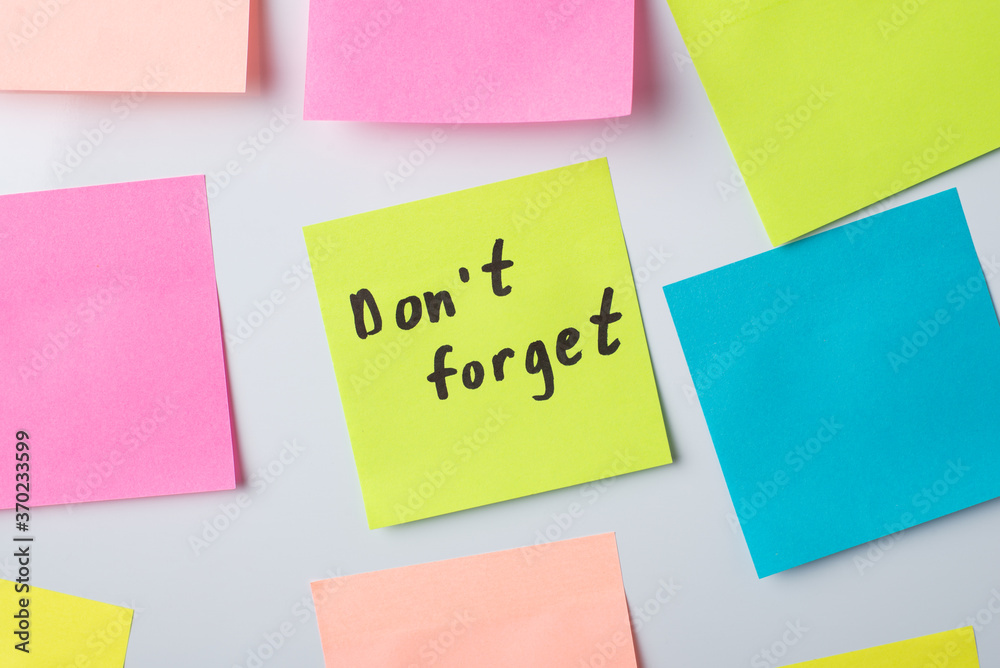 Sticky note with text Don't forget among other notes on a whiteboard in ...