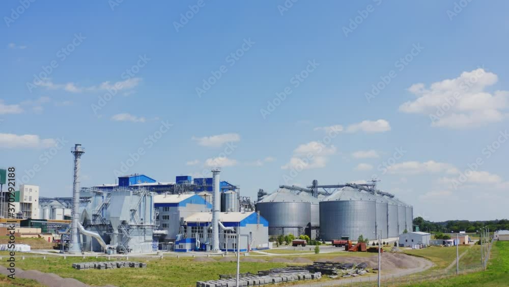 Exterior of modern plant. Large metal containers for grain storage on ...