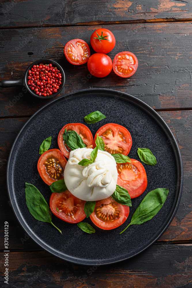 Handmade burrata cheese served with fresh tomatoes and basil leaves ...