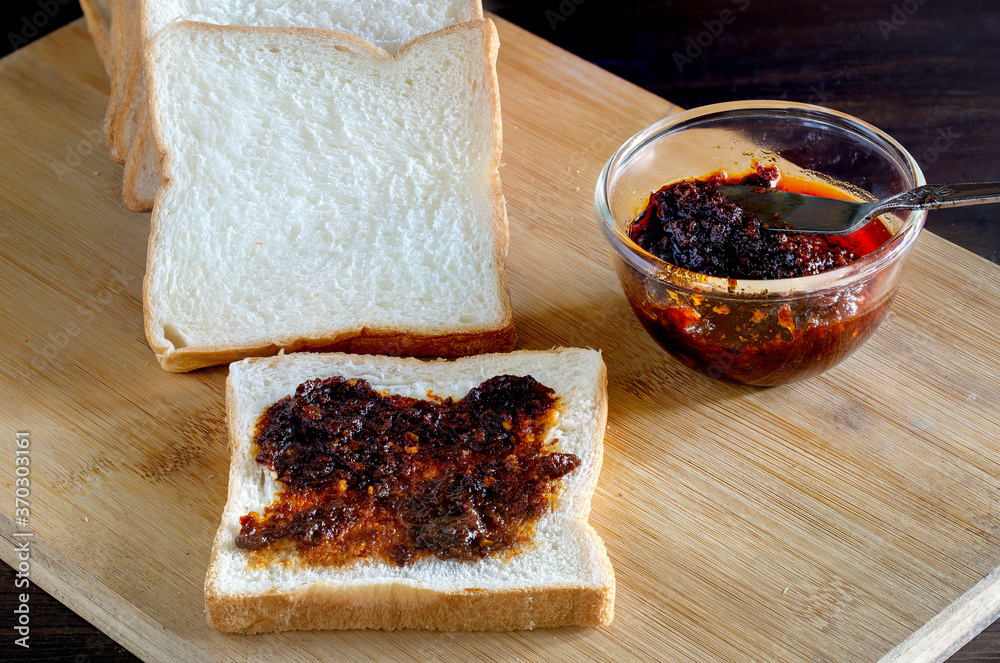 Chili paste smear on front of bread for eat, and pile of breads on ...
