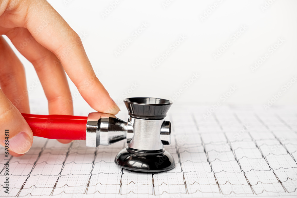female hand applies a stethoscope to the ECG. listen to pulse and ...