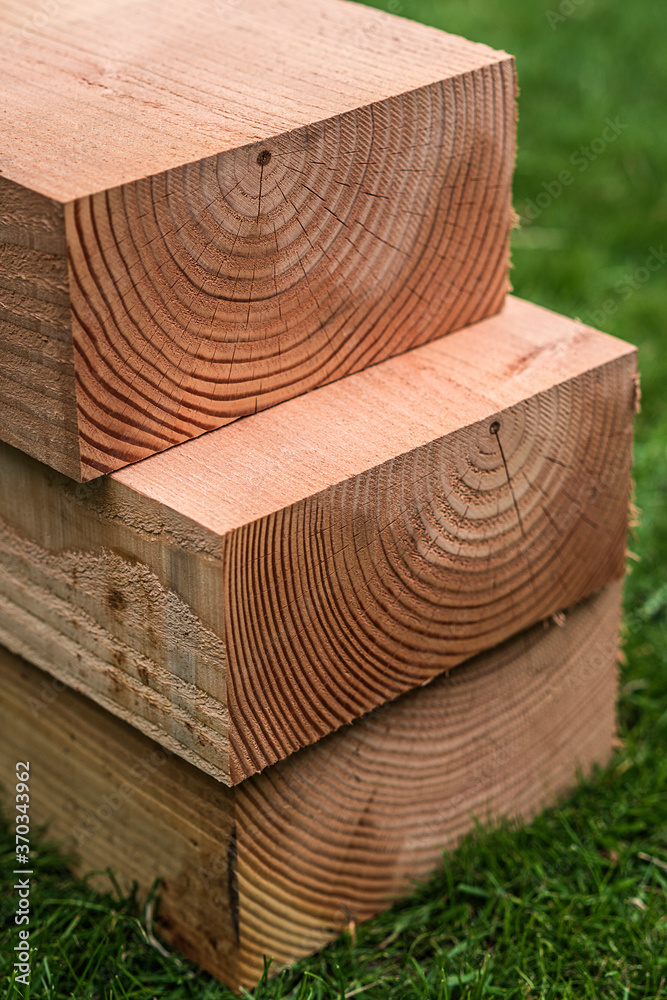 Three large thick wooden timber beams stacked on top of each other on ...