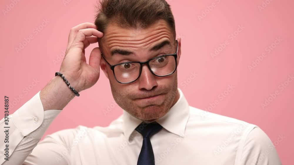 clueless young elegant guy in white shirt wearing glasses, scratching ...