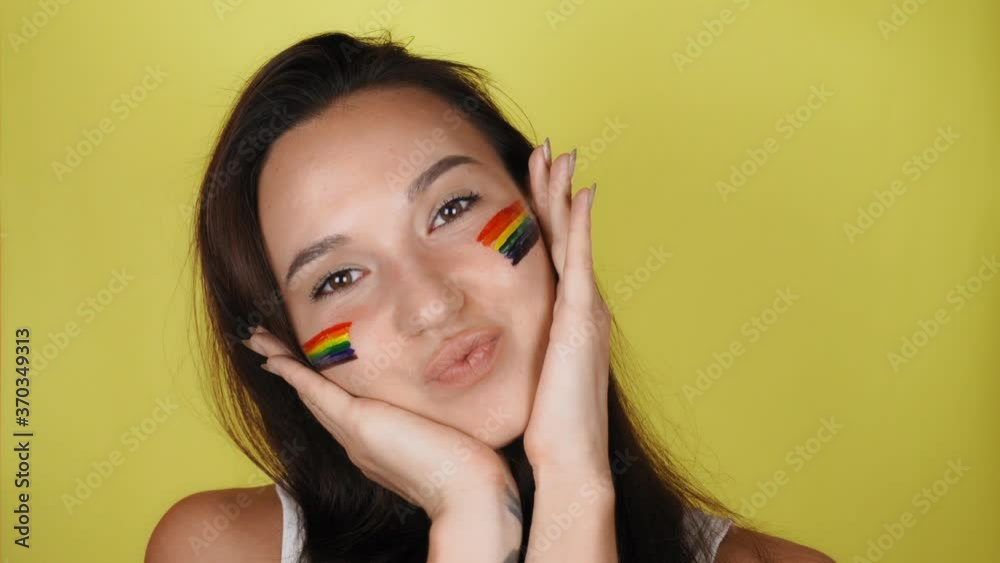 Vídeo do Stock: Happy woman with a rainbow pattern on her face close-up ...