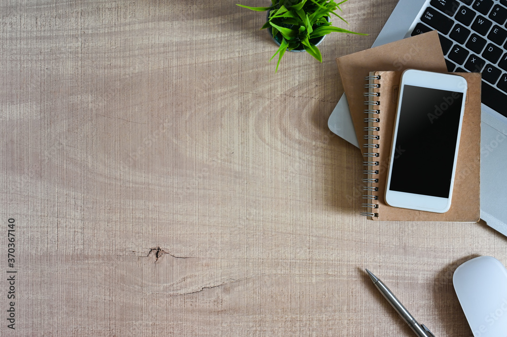 Office desk wood table with smartphone with empty screen, laptop, and ...