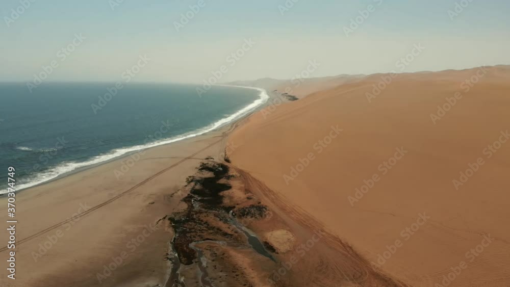 Aerial view of Sandwich Harbour in Namibia, where dunes meet the ocean ...