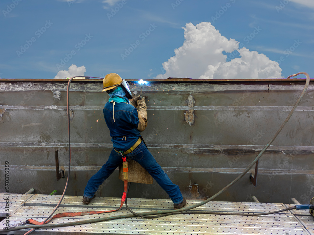 The welder is welding a steel structure work with process Flux Cored ...