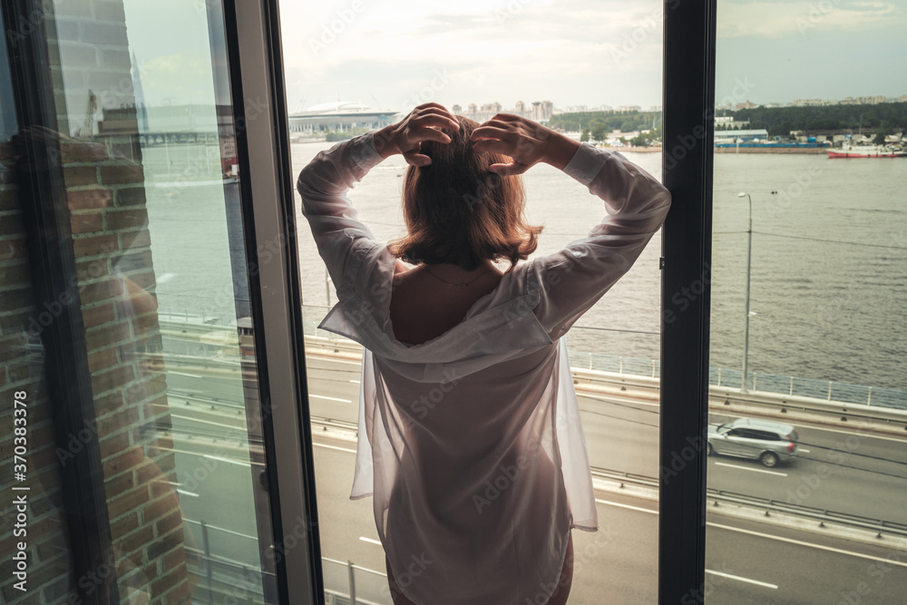 Back view of beautiful young happy woman in a transparent nightgown ...