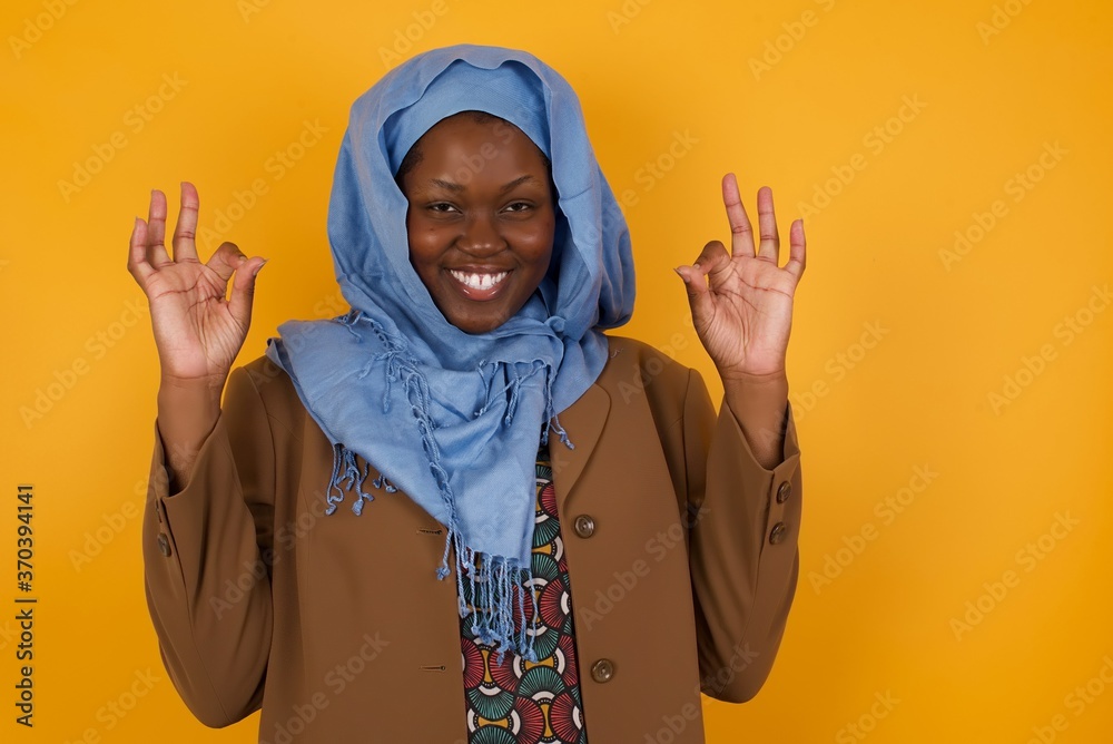 Glad attractive woman shows ok sign with both hands as expresses ...