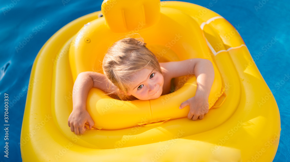 Child in swiming pool in yellow inflatable waist baby Swim Float on ...