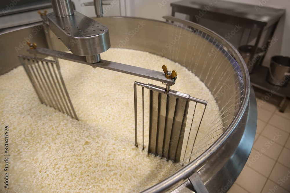 Adding water to curd and whey in tank at cheese factory Stock Photo ...