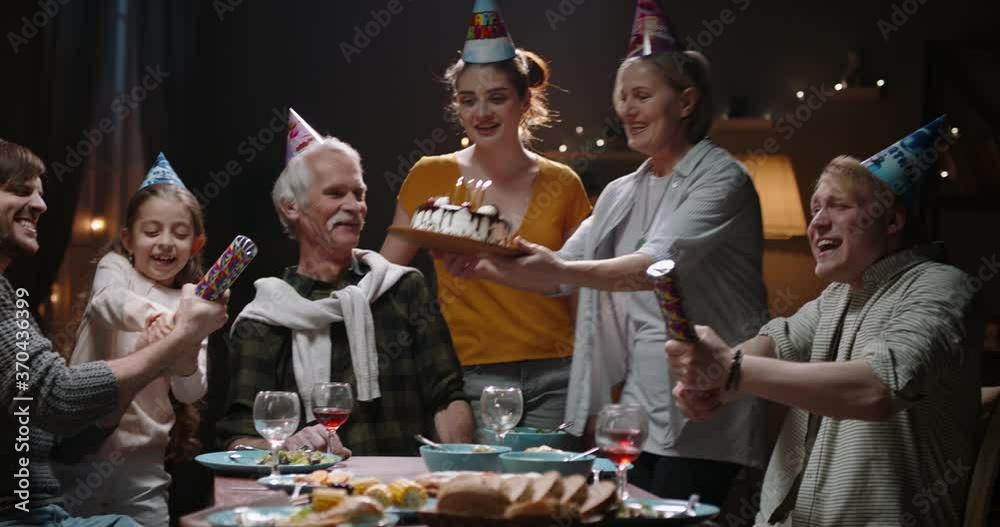 Happy family celebrating birthday. Old moustached man blowing out ...