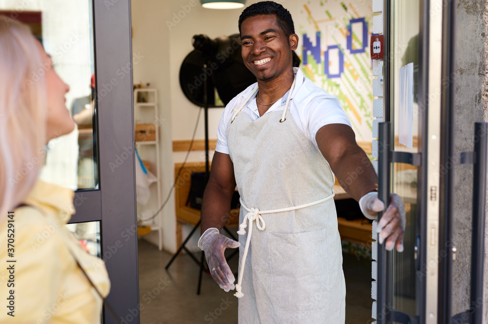 you are welcome. cafe worker welcomes clients, open-minded black man in ...