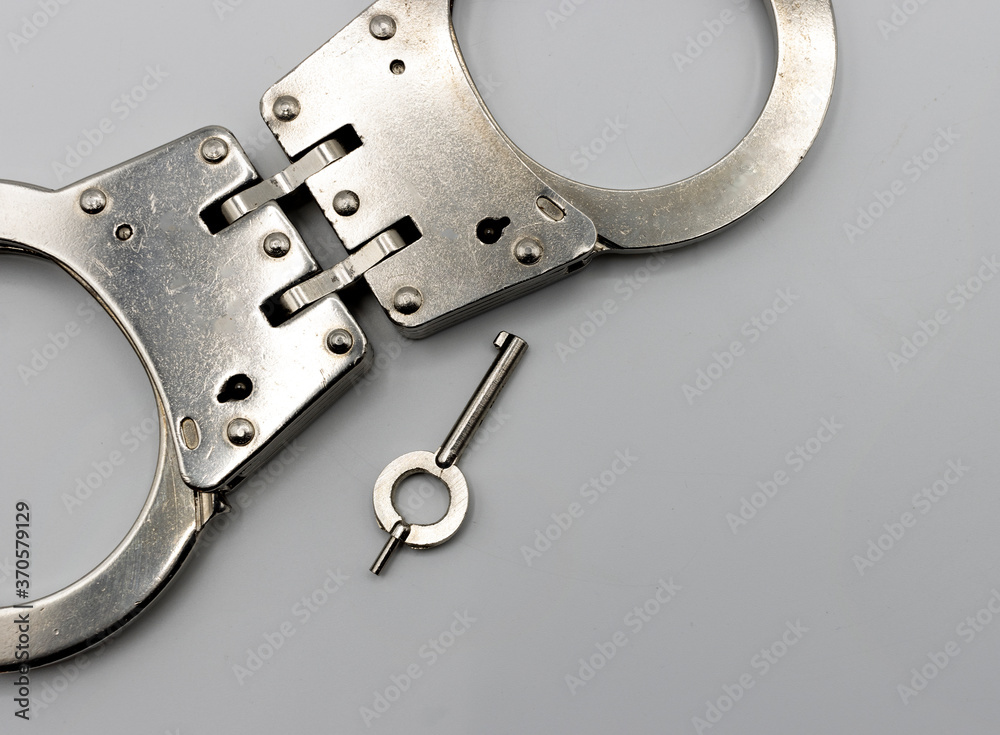 Isolated photo of closed police handcuffs on a clean background with ...