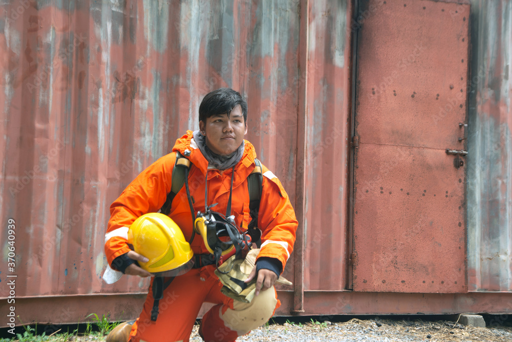 The portrait of young Asian firefighters are wearing orange fire ...