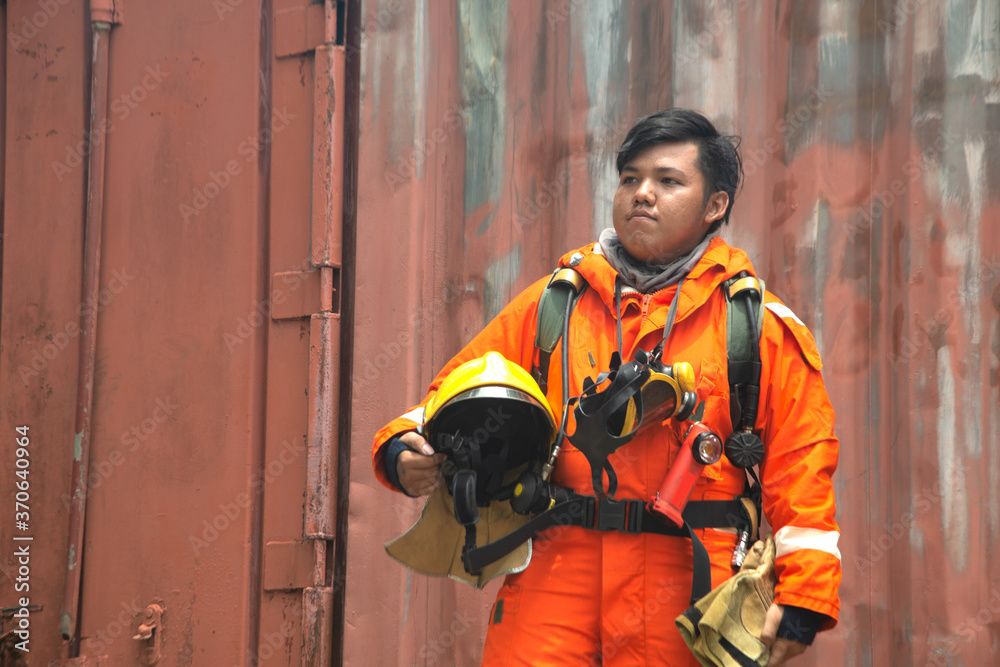 The portrait of young Asian firefighters are wearing orange fire ...
