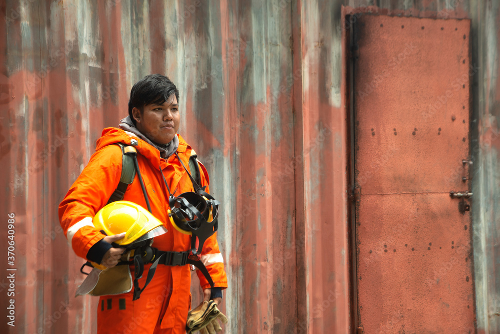 The portrait of young Asian firefighters are wearing orange fire ...