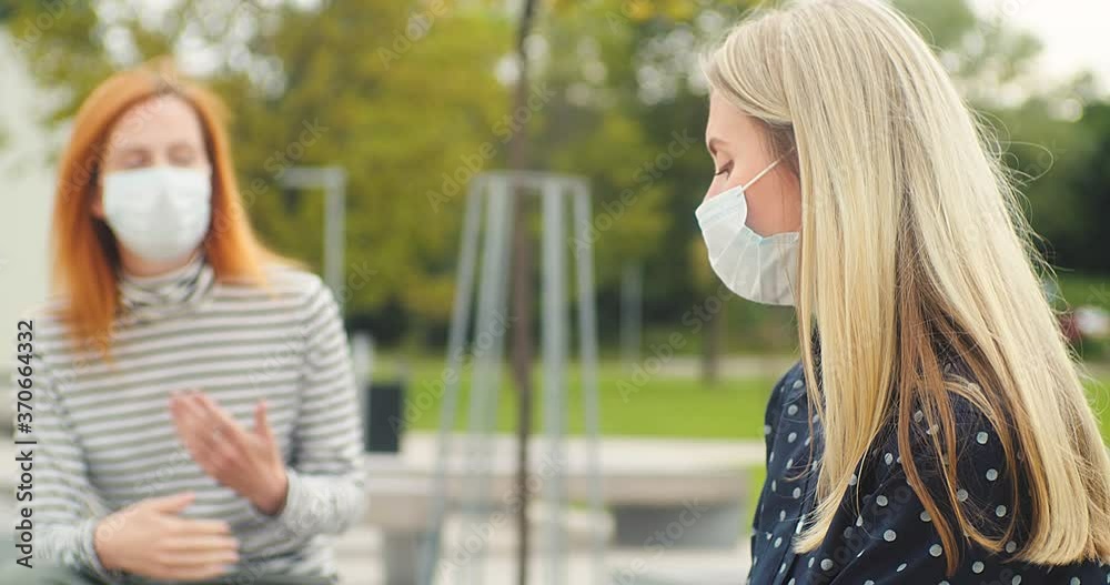 Female colleagues entrepreneurs wearing masks working over tablet ...