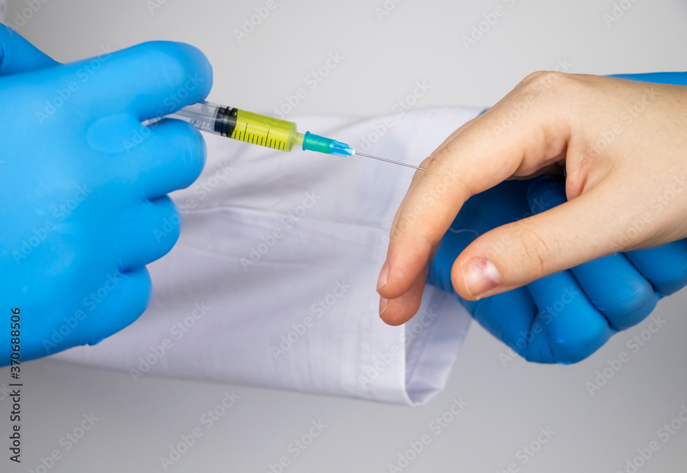 Orthopedic surgeon gives an injection in the finger joint. Treatment of ...