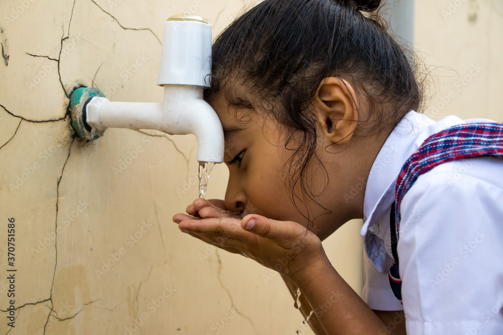 Image of a thirsty school girl drinking water from a tap Stock Photo | Adobe Stock