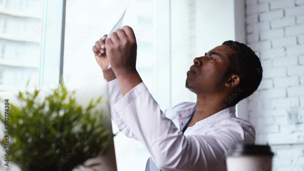 Close-up face of African American black man doctor examining MRI brain ...
