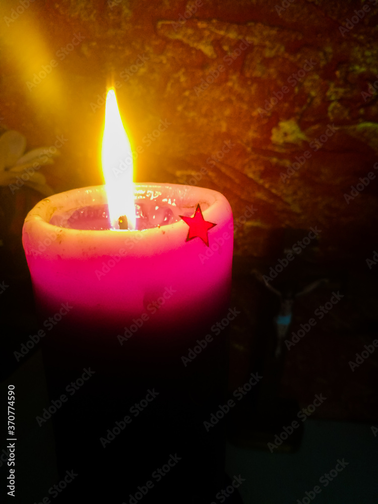 Lightening candle with a star on its body for decoration as a symbol of ...