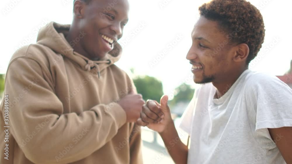 Two black friends, two African American students greet each other with ...