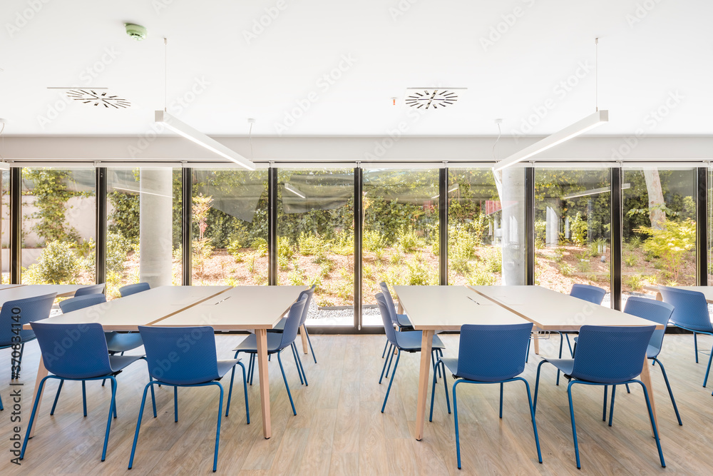 Modern style office interior with square tables and blue stools on ...