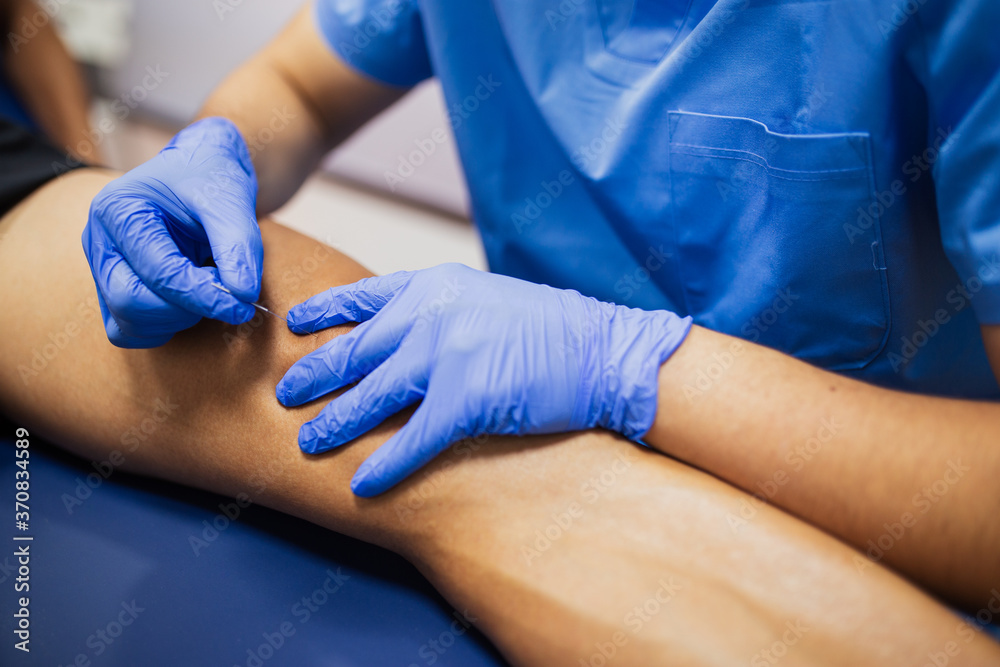 From above of crop faceless sports medicine doctor in sterile gloves ...